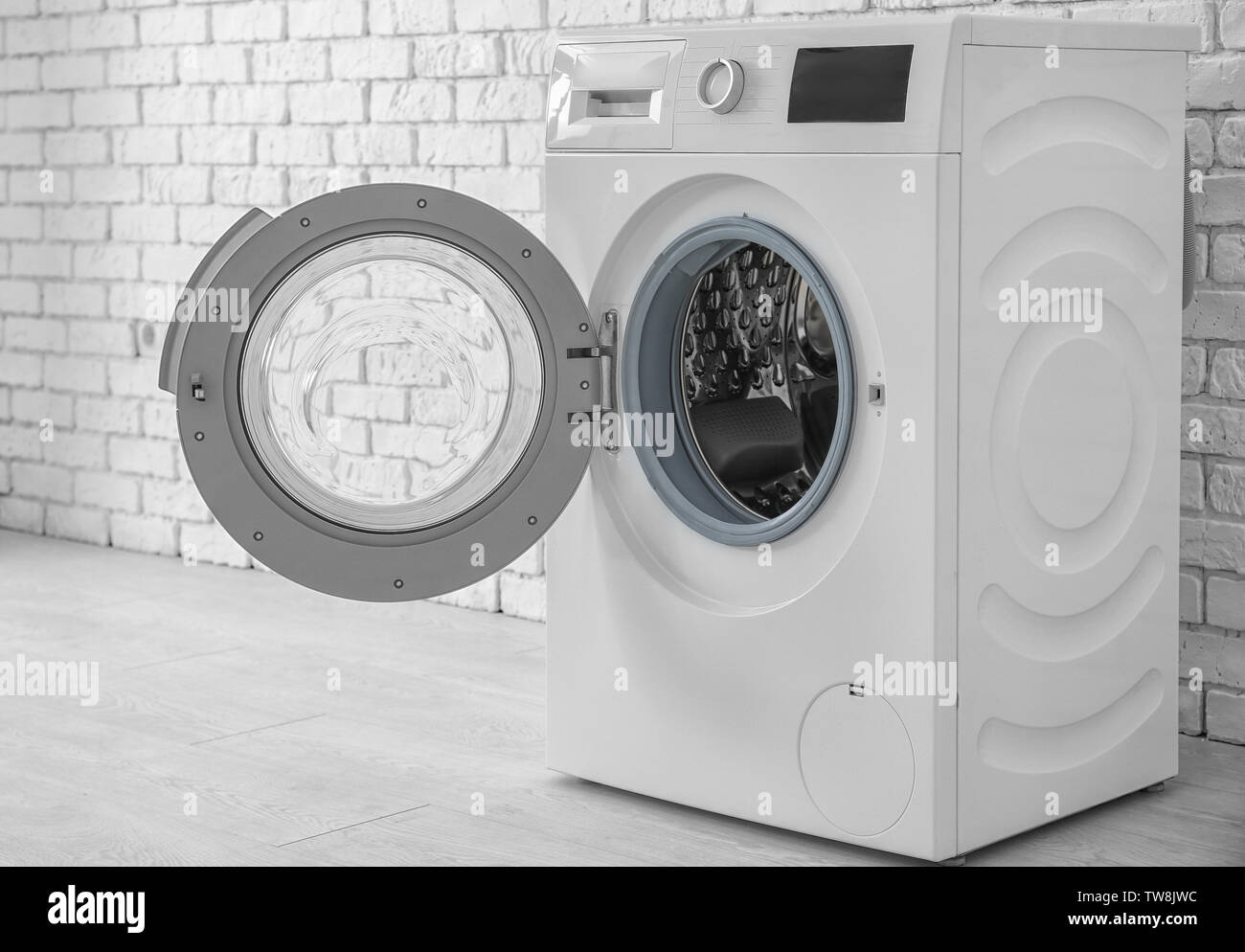 Modern washing machine near brick wall Stock Photo - Alamy