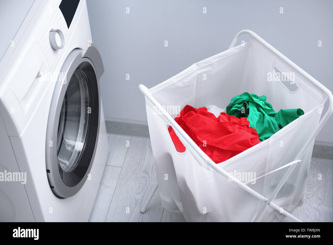 Basket with laundry and washing machine in bathroom Stock Photo - Alamy