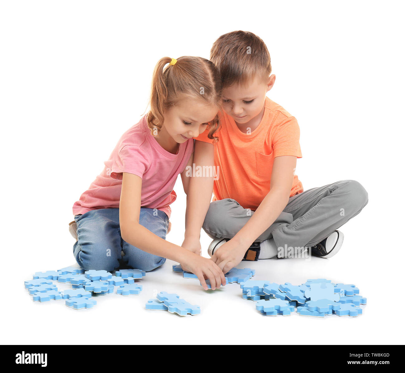 Cute little children playing with puzzle on white background Stock ...