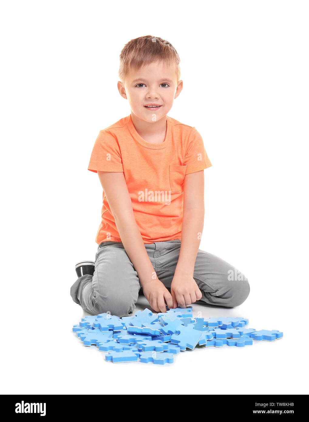 Cute little boy playing with puzzle on white background Stock Photo - Alamy