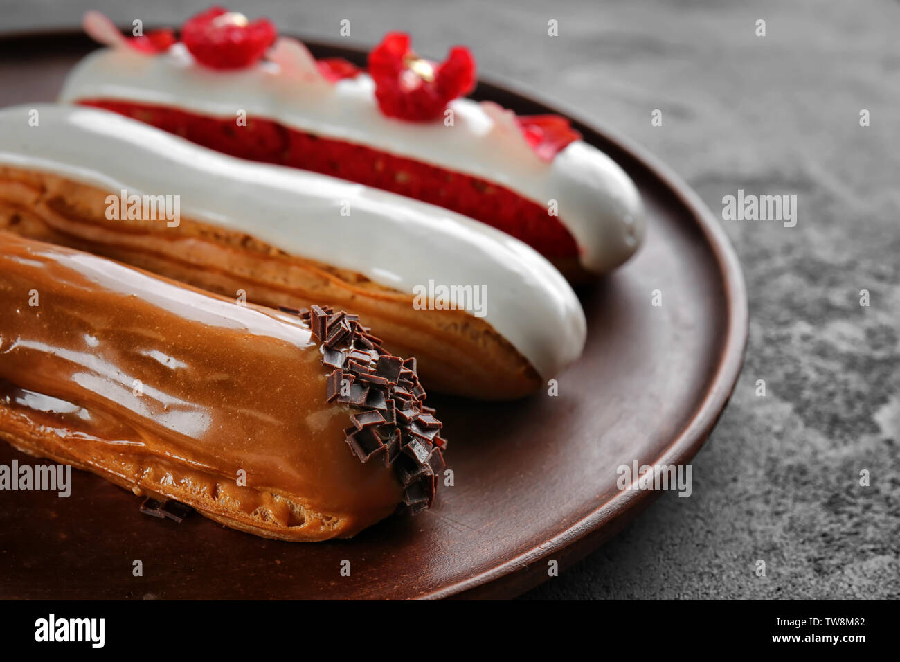 Various tasty eclairs on tray Stock Photo - Alamy