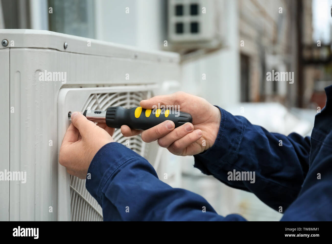 Male technician fixing air conditioner outdoors Stock Photo - Alamy