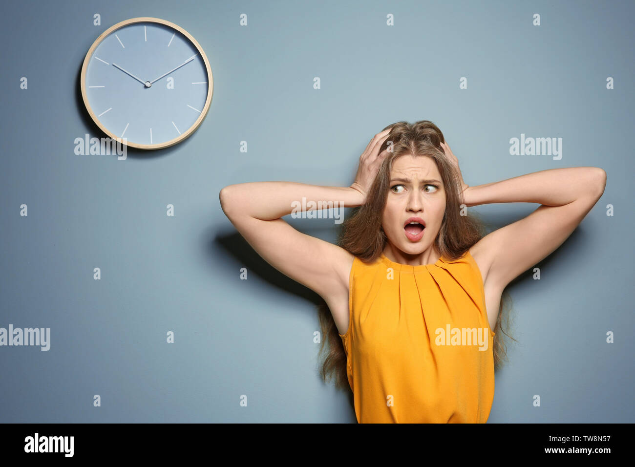 Shocked manager near wall with clock Stock Photo - Alamy