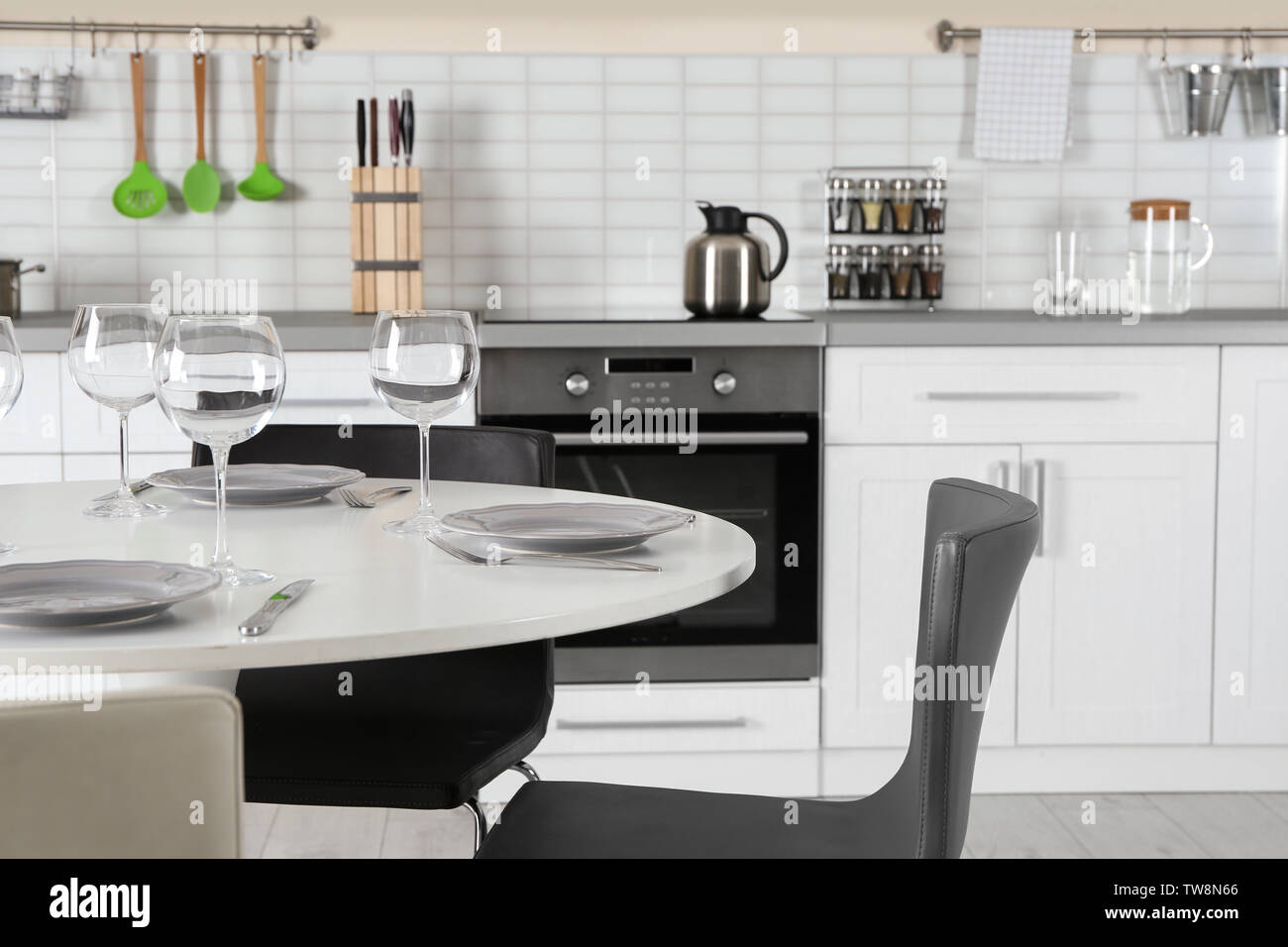 Modern kitchen interior with served table and electric oven Stock Photo ...