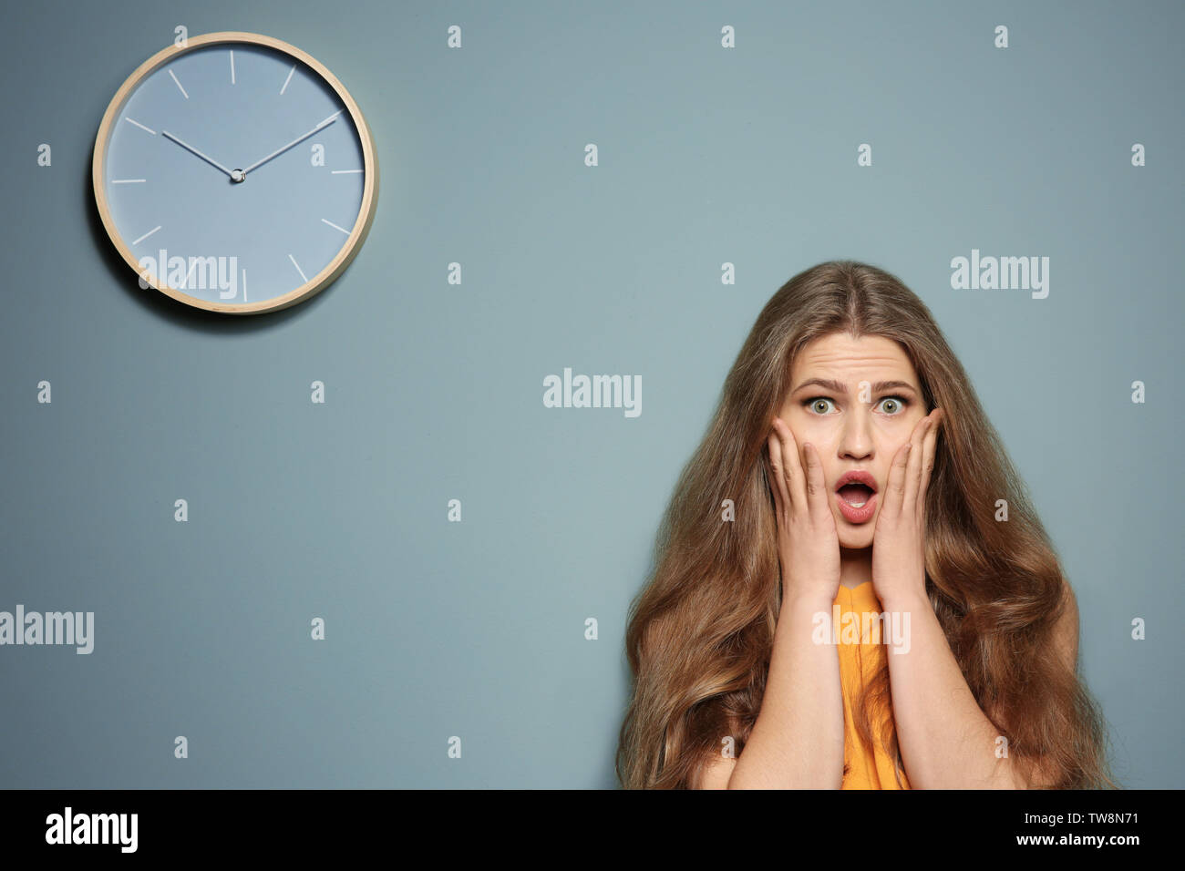 Shocked manager near wall with clock Stock Photo - Alamy