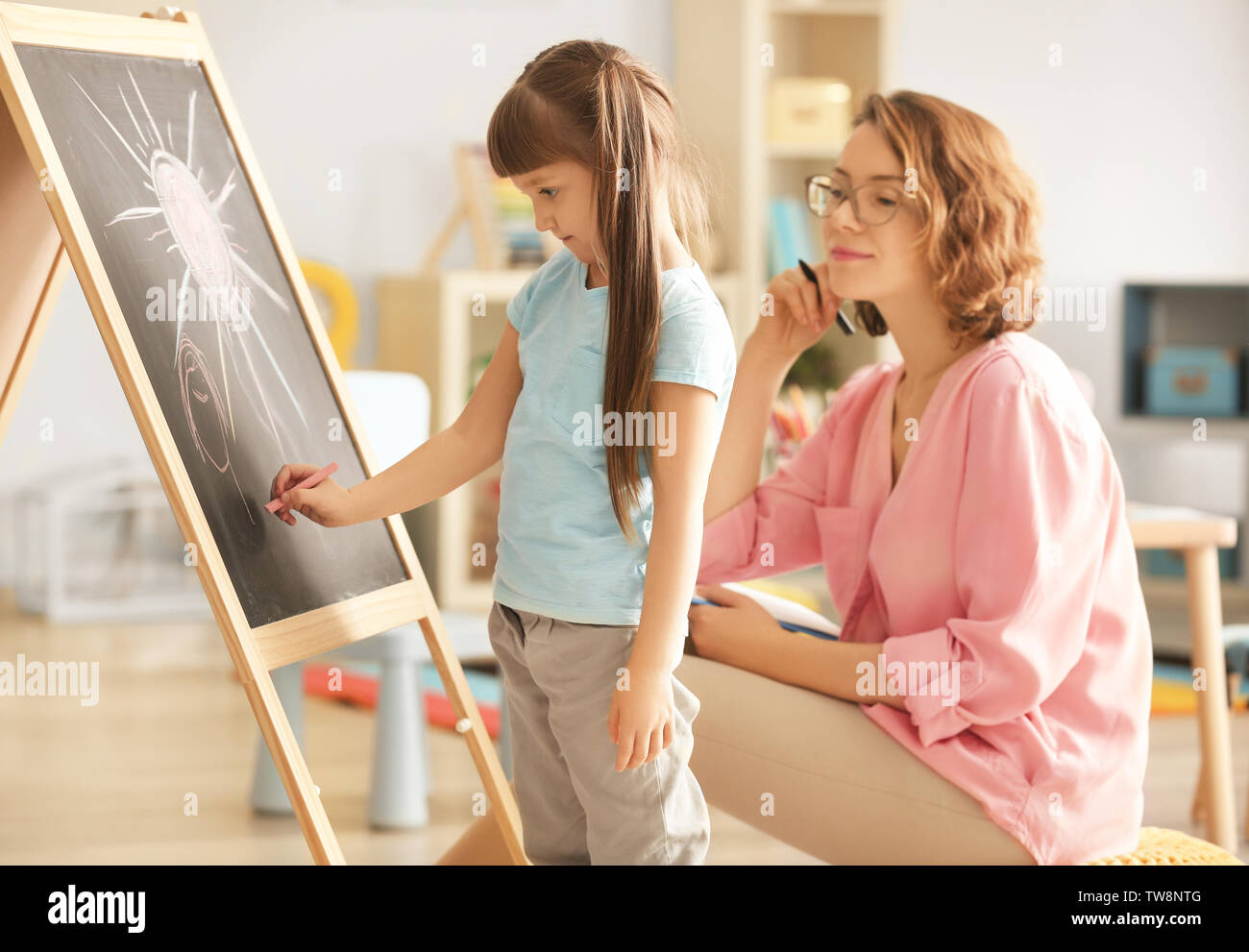 Cute little girl with female psychologist during art therapy Stock ...