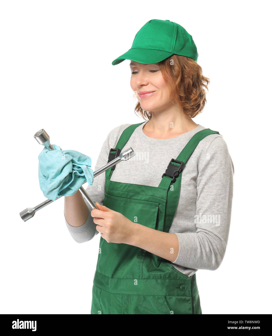 Female auto mechanic wiping lug wrench with rag on white background ...