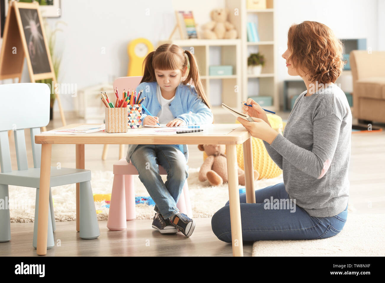 Female psychologist with cute little girl during art therapy Stock ...