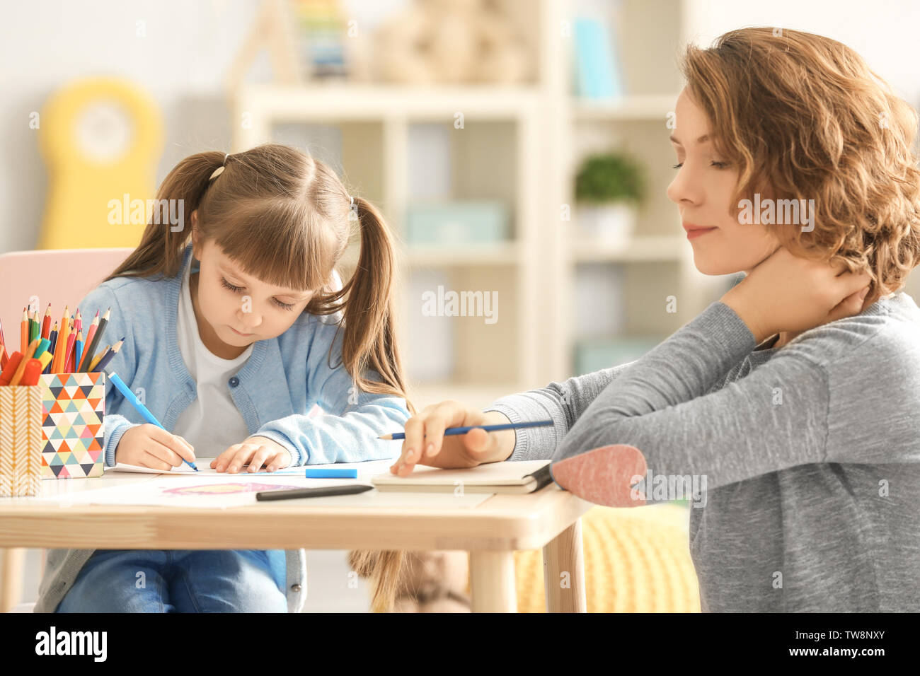 Female psychologist with cute little girl during art therapy Stock ...