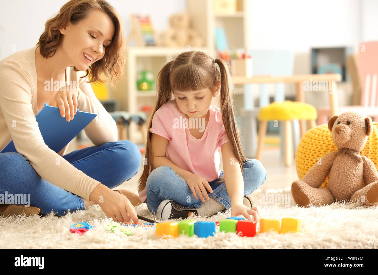 Female psychologist with cute little girl during play therapy Stock ...