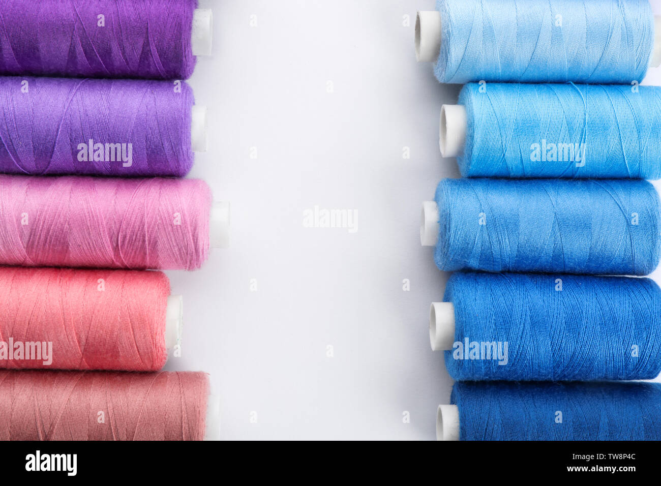 Colorful sewing threads on white background Stock Photo - Alamy