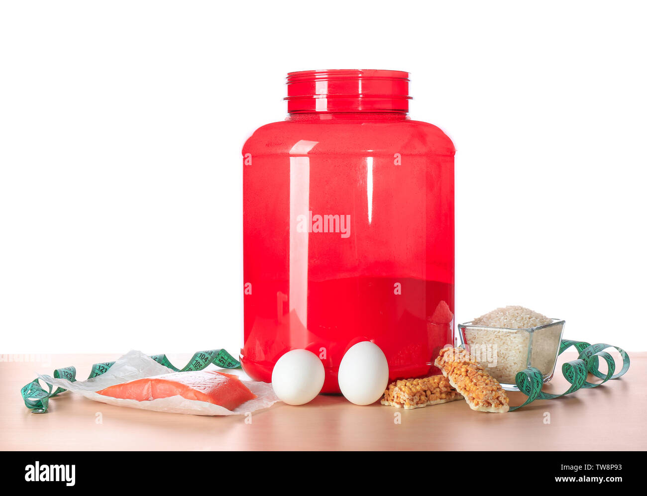 Protein powder in jar and products on table against white background ...