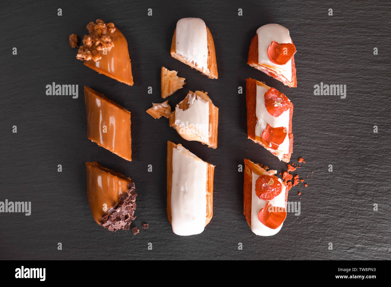 Tasty cut eclairs on black background, top view Stock Photo - Alamy