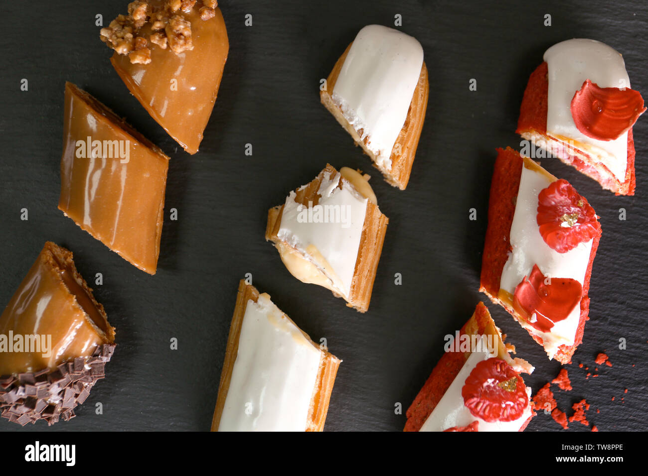 Tasty cut eclairs on black background, top view Stock Photo - Alamy