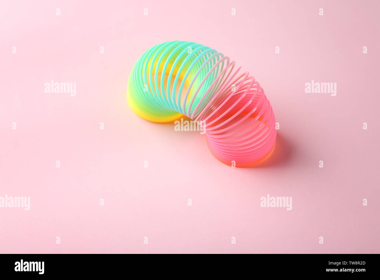 Rainbow slinky on color background Stock Photo - Alamy