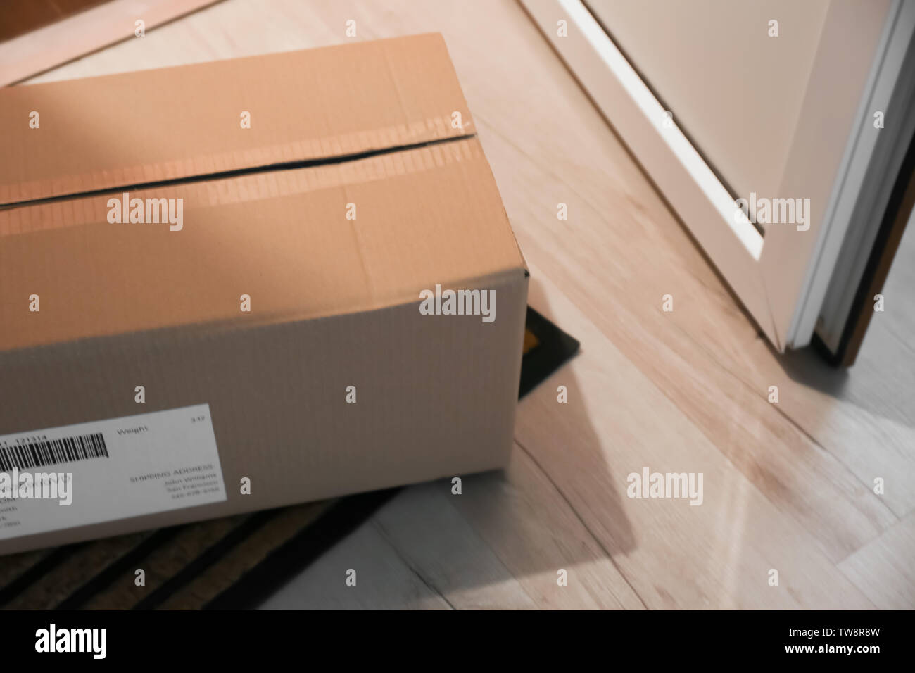 Parcel box on floor near open door Stock Photo - Alamy