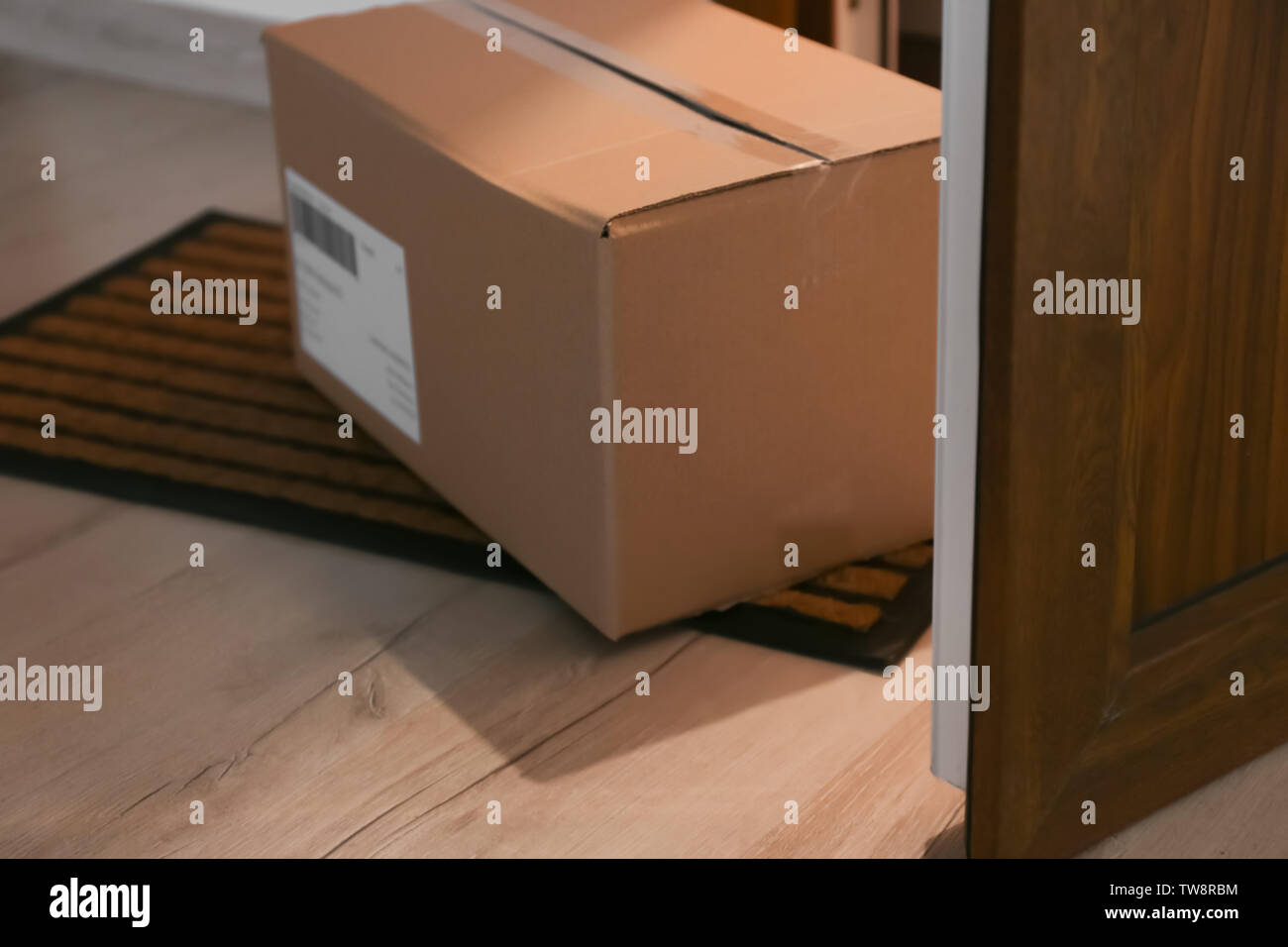 Parcel box on floor near open door Stock Photo - Alamy