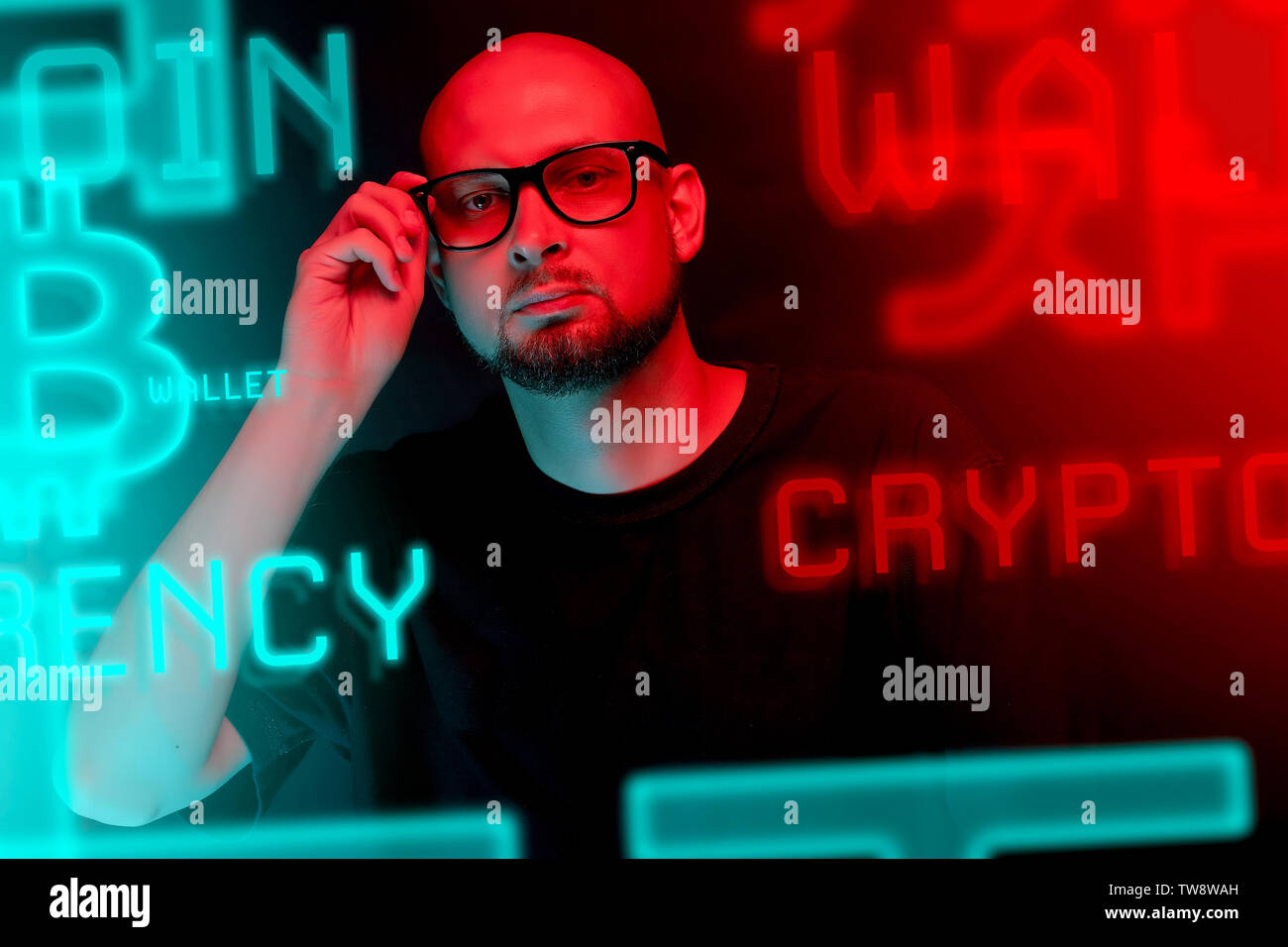 Attractive bald man with beard in glasses on black neon light ...
