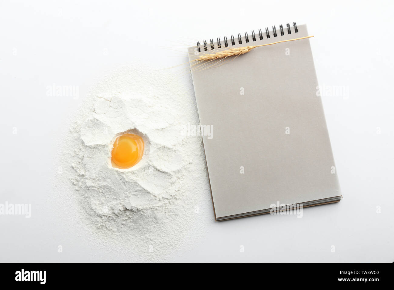 Flour with egg for bread and notebook on white background Stock Photo ...