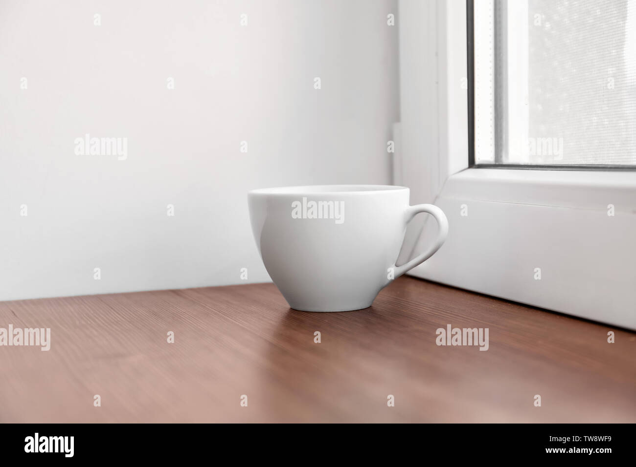 Cup of coffee on window sill Stock Photo - Alamy