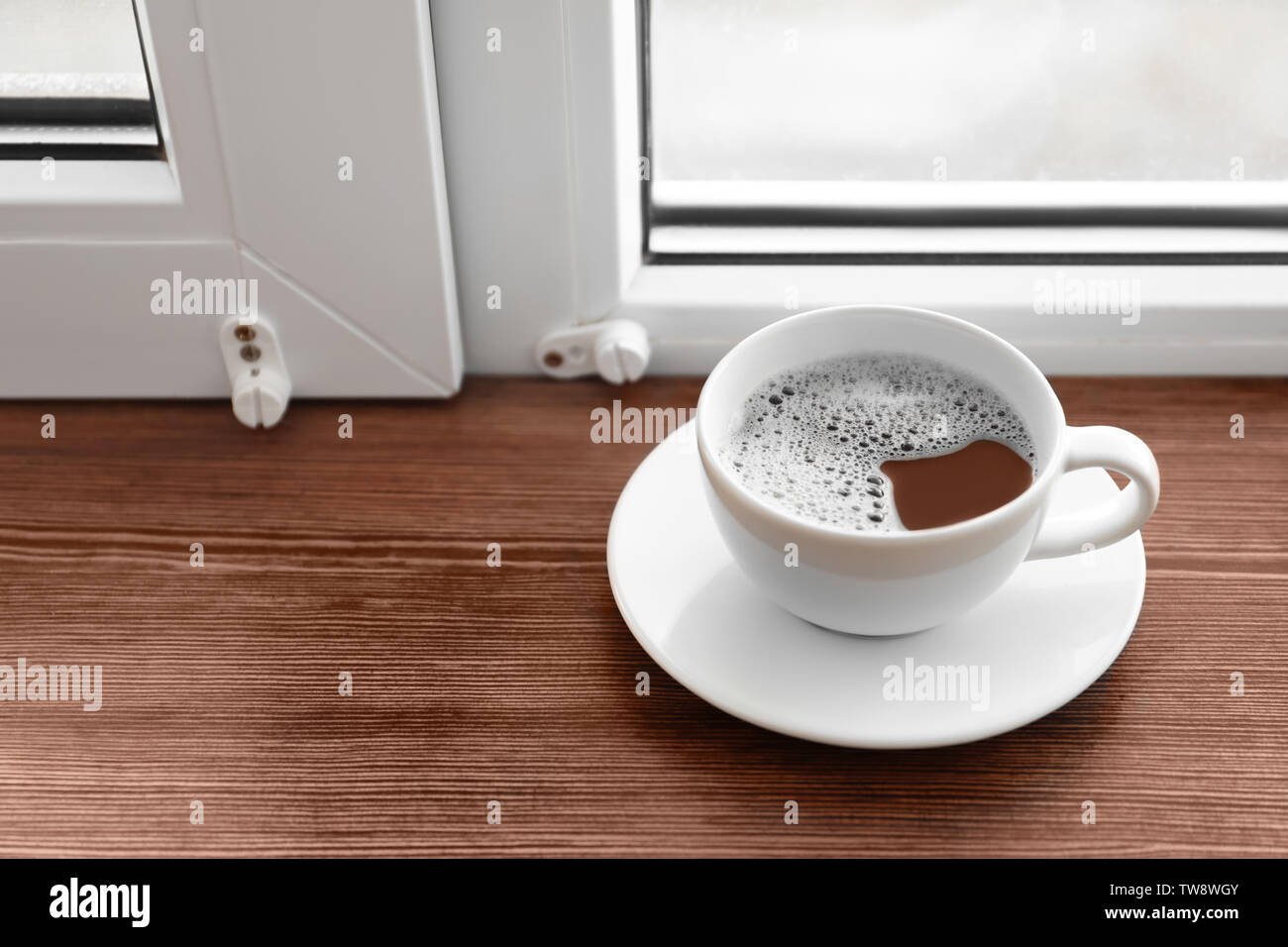 Cup of coffee on window sill Stock Photo - Alamy