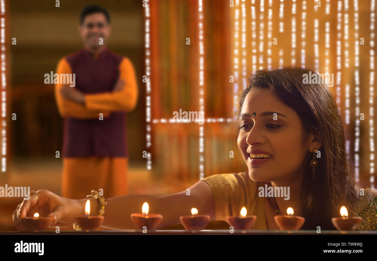 Woman decorating the house with diya on the occasion of Stock Photo - Alamy