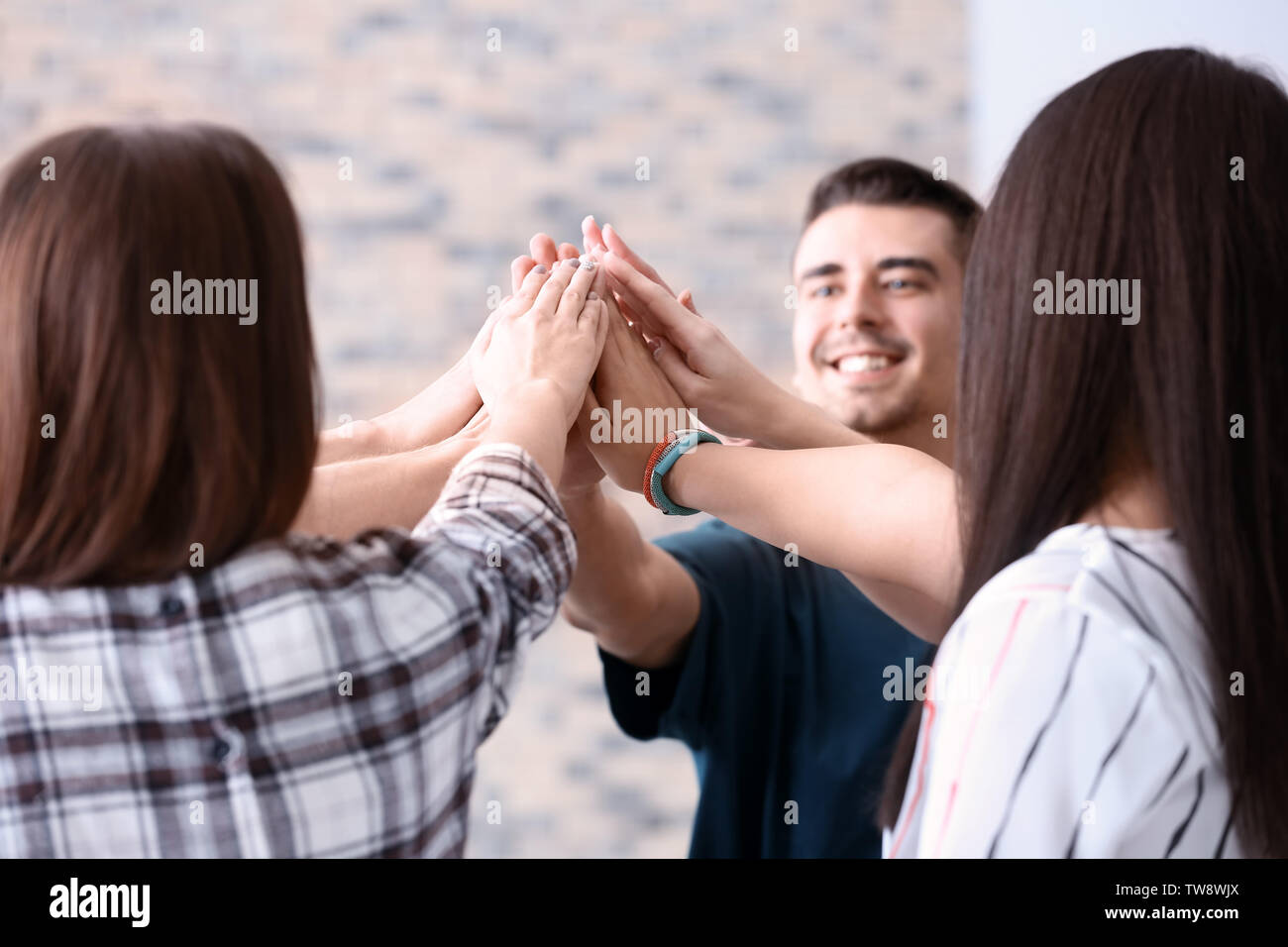 People putting hands together indoors. Unity concept Stock Photo - Alamy