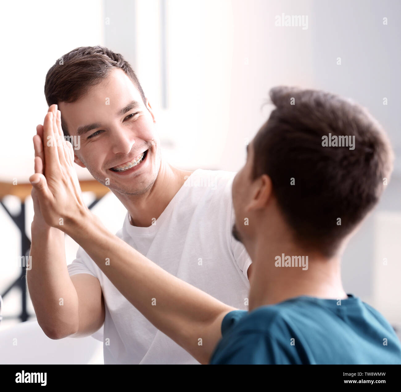 Men giving high five indoors. Unity concept Stock Photo - Alamy