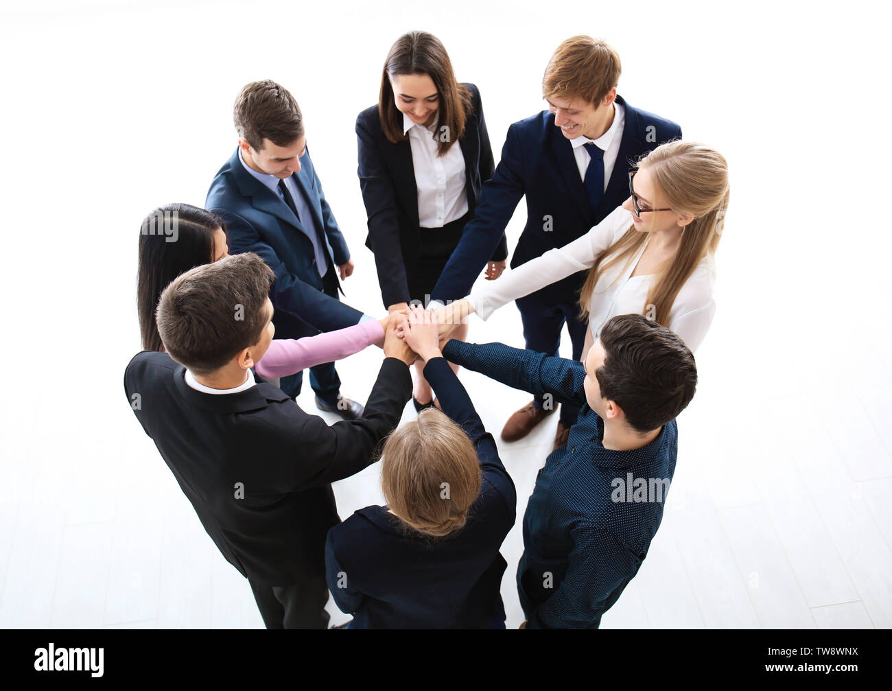 People putting hands together indoors. Unity concept Stock Photo - Alamy