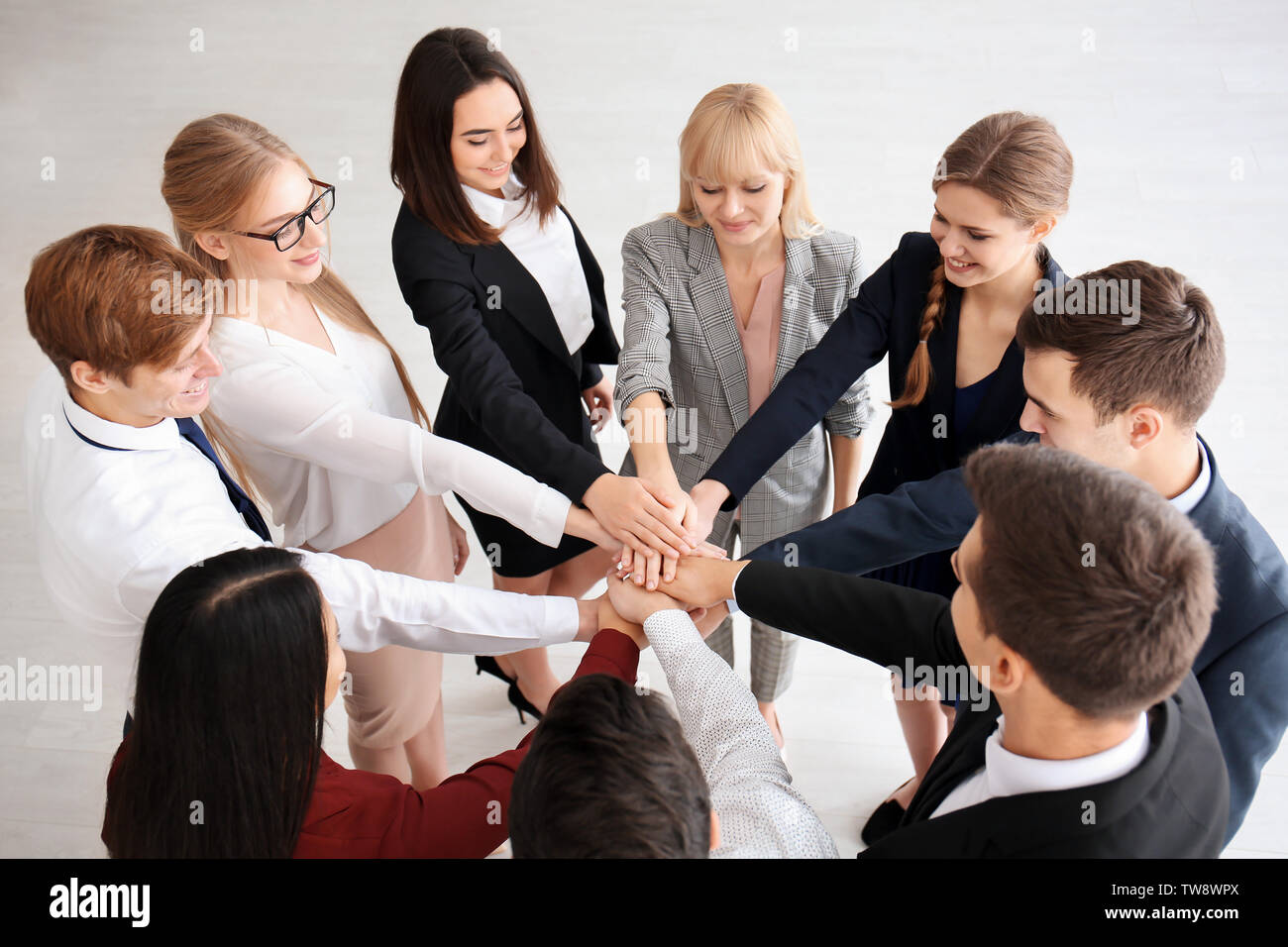 People putting hands together indoors. Unity concept Stock Photo - Alamy