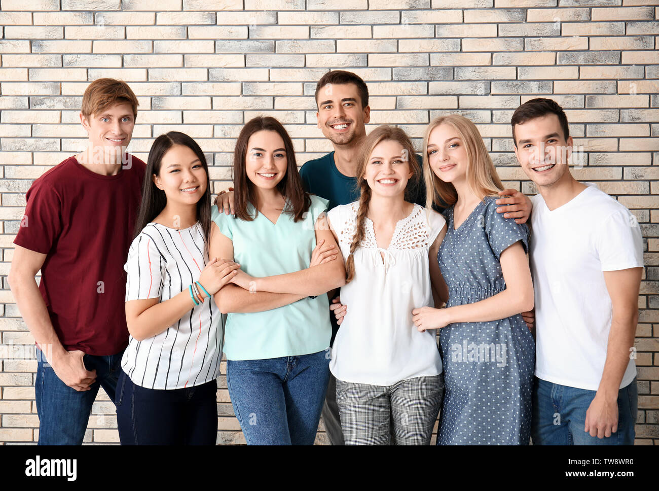 People standing together near brick wall. Unity concept Stock Photo - Alamy