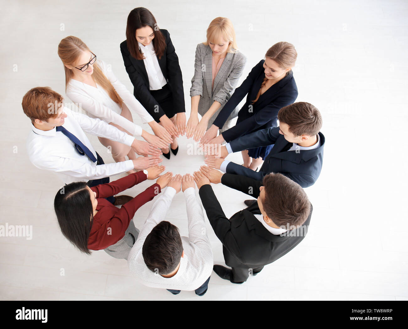 People putting hands together indoors. Unity concept Stock Photo - Alamy
