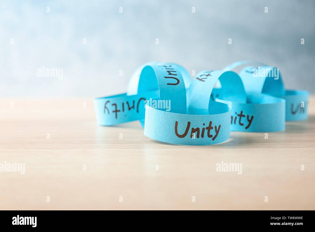 Paper chain with word UNITY on wooden background Stock Photo - Alamy