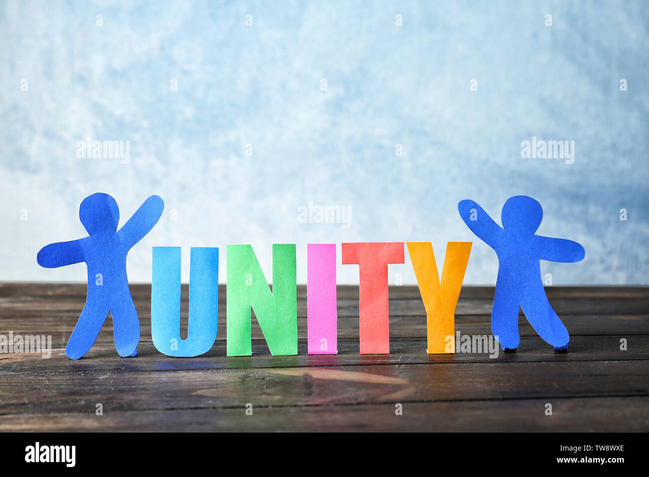 Paper people and word UNITY on wooden table Stock Photo - Alamy