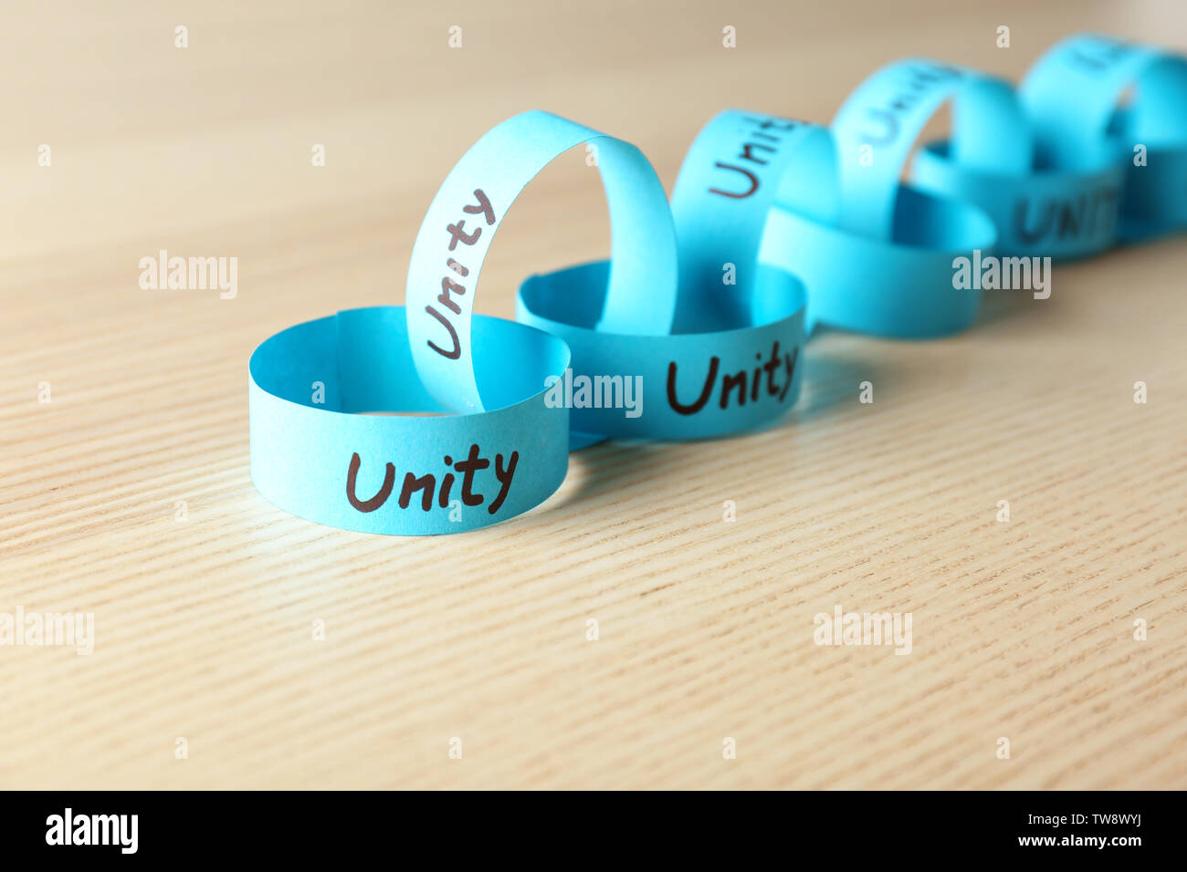 Paper chain with word UNITY on wooden background Stock Photo - Alamy