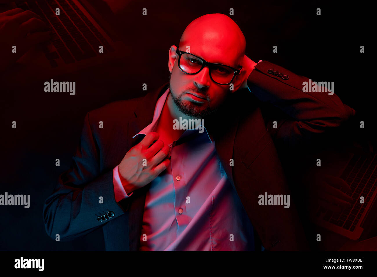 Attractive bald man with beard with glasses on neon light background ...