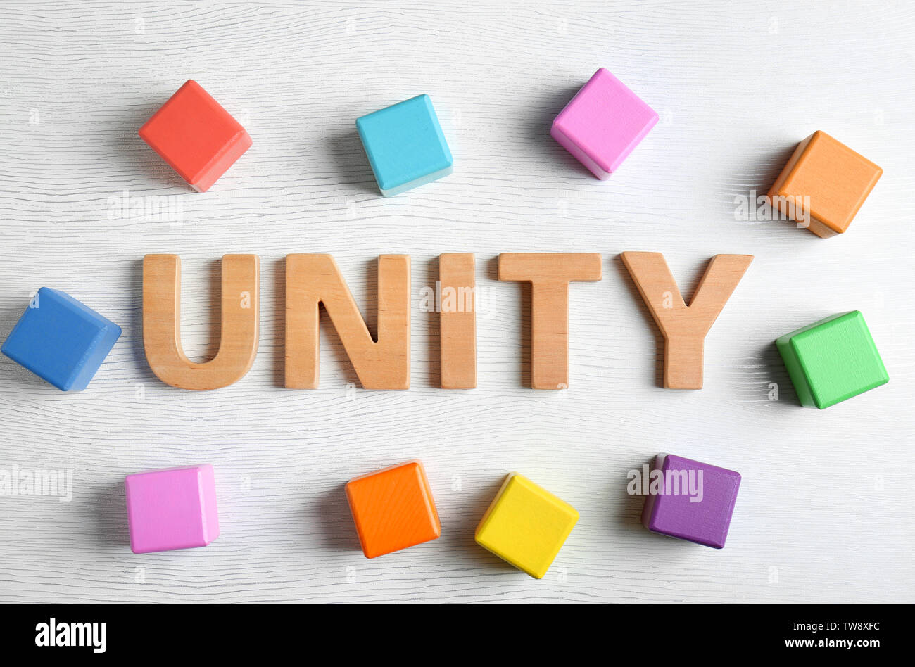 Word UNITY made of letters with cubes on wooden background Stock Photo ...