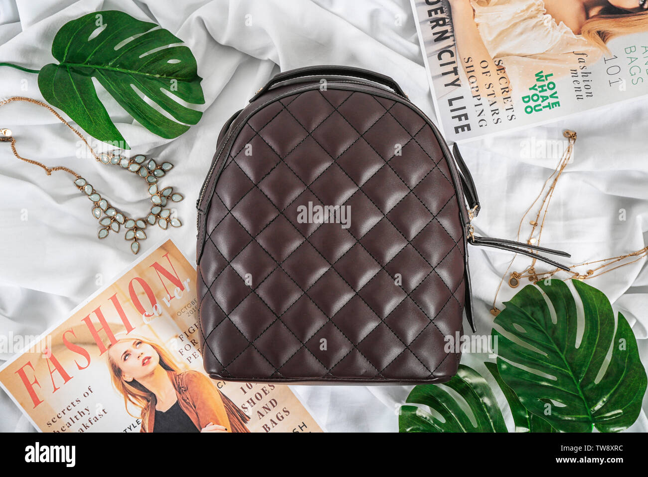 Composition with stylish backpack and magazines on fabric background ...