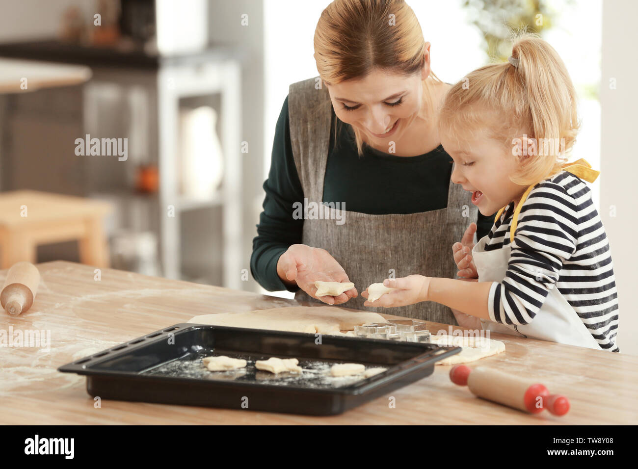 Mother and daughter with dough at table indoors Stock Photo - Alamy