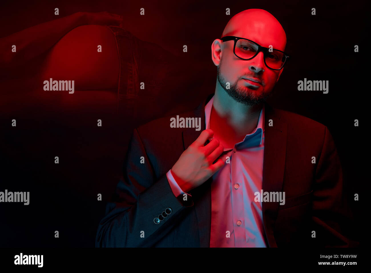 Attractive bald man with beard with glasses on neon light background ...