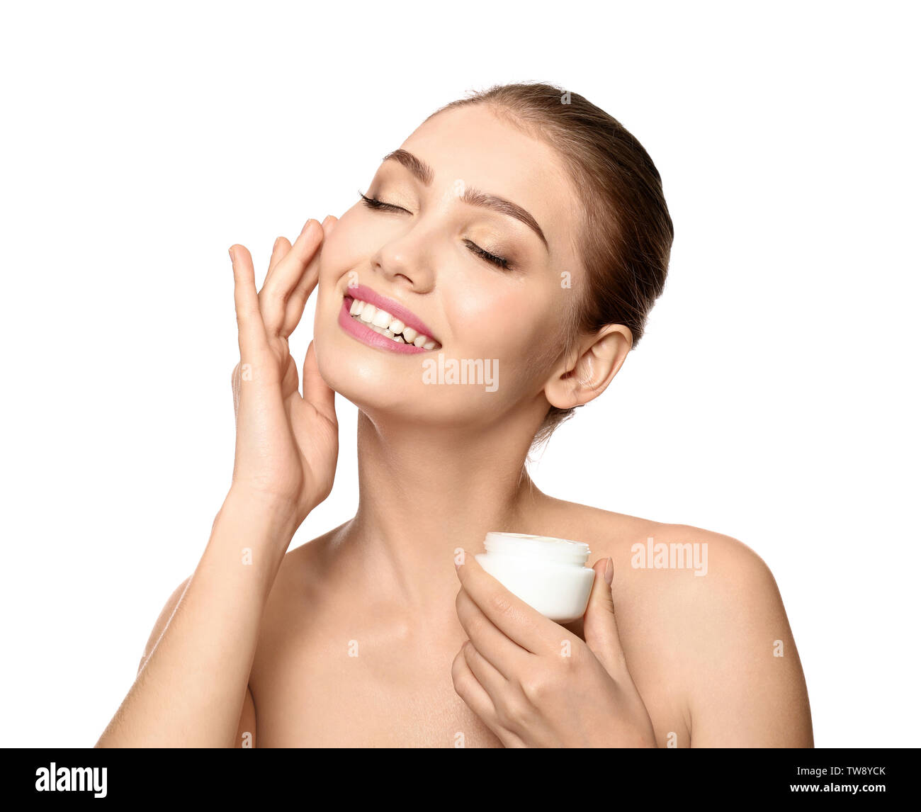 Portrait of beautiful young woman applying cream on skin against white ...