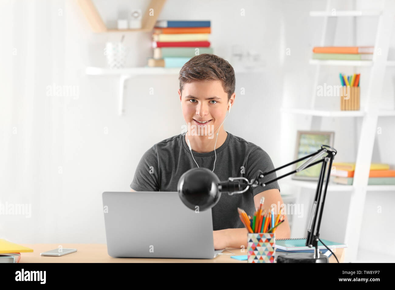 Stylish teenager using laptop in room Stock Photo - Alamy