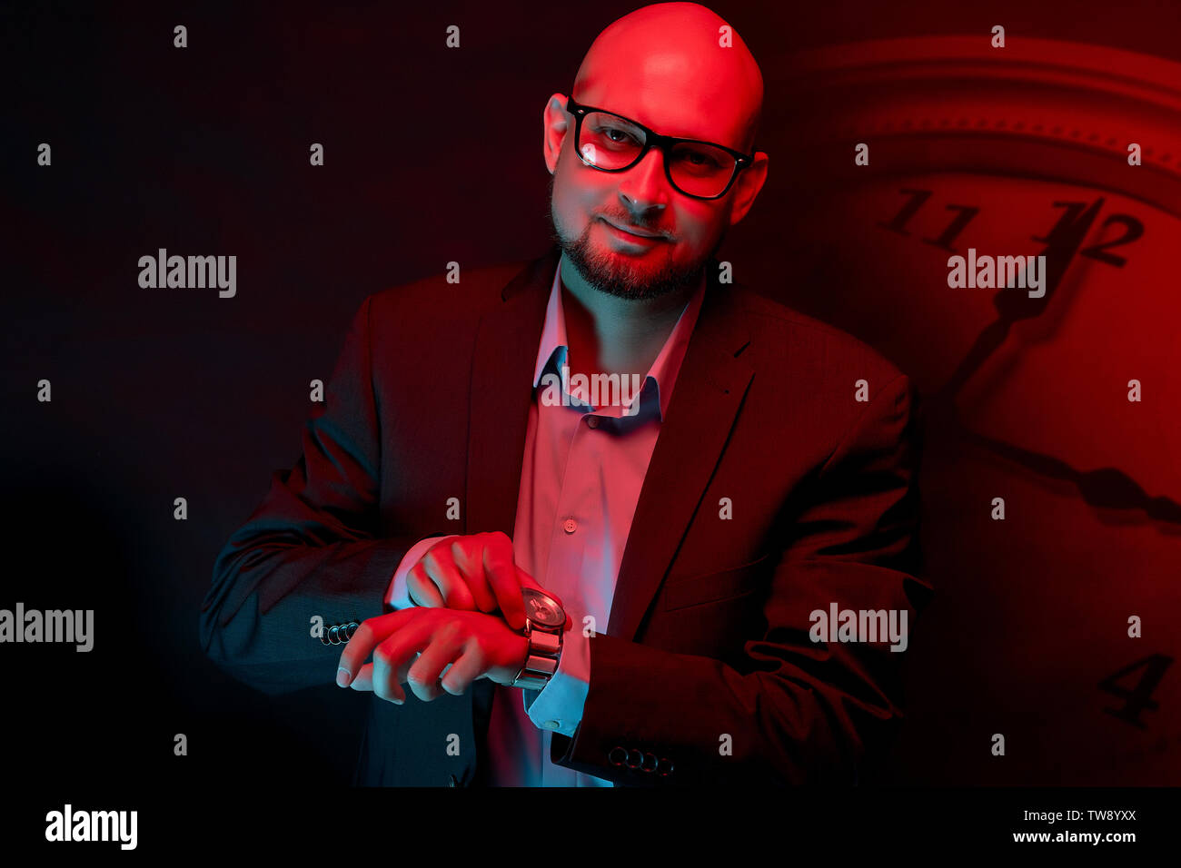Attractive bald man with beard with glasses on neon light background ...