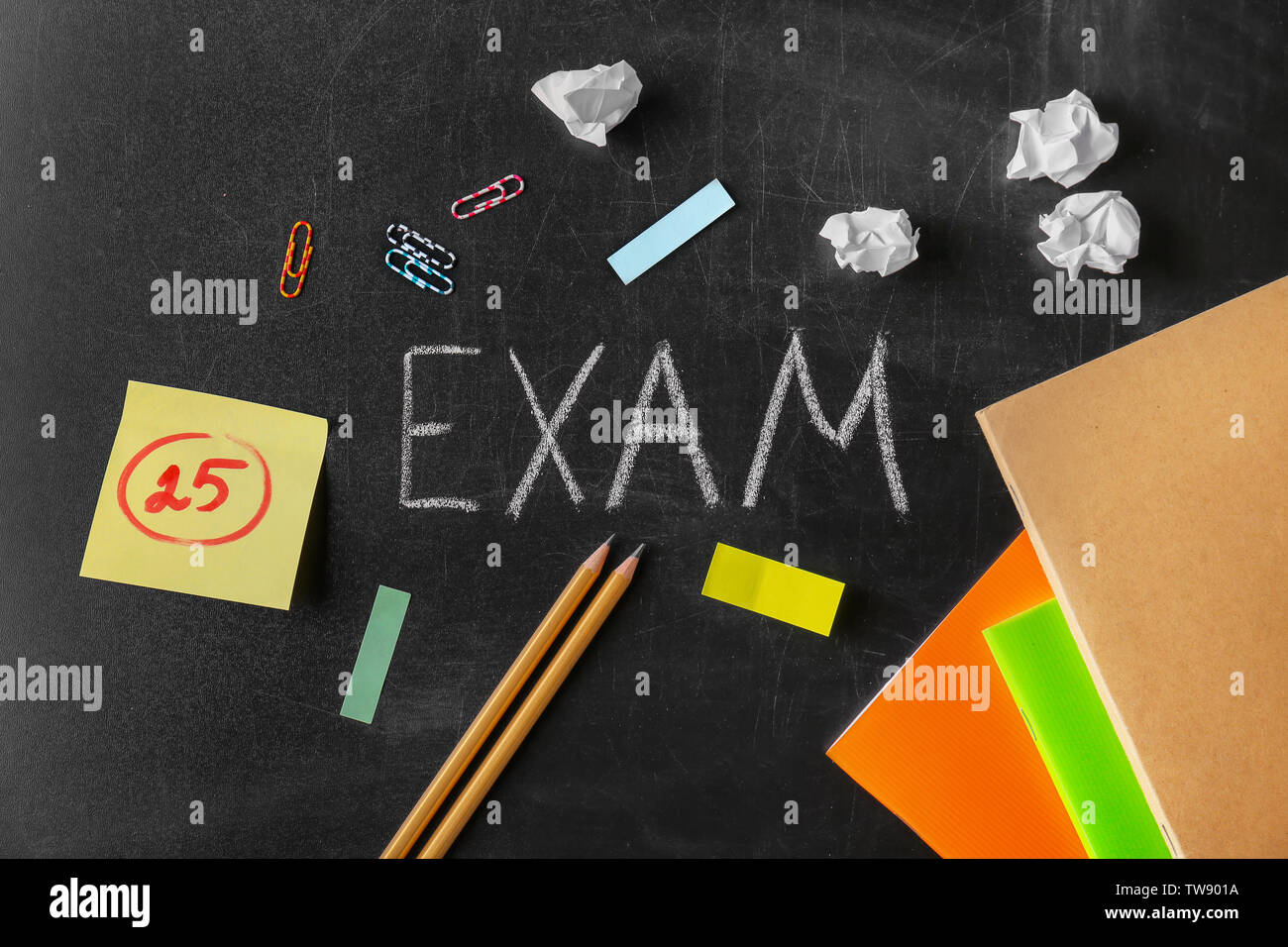 Stationery and word EXAM written on blackboard Stock Photo - Alamy