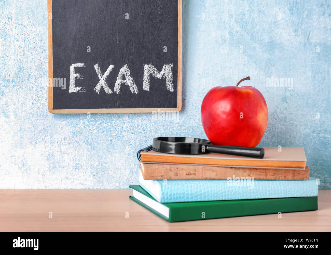 Blackboard with word EXAM, notebooks and apple on table Stock Photo - Alamy