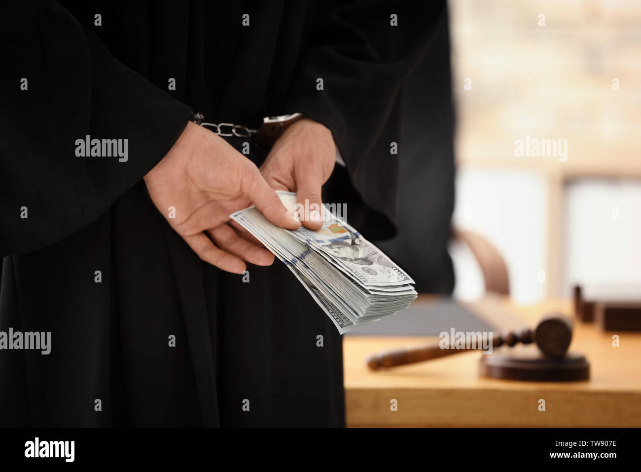 Male judge in handcuffs holding bribe, closeup Stock Photo - Alamy