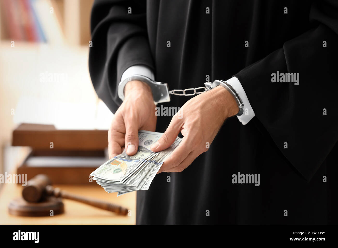 Male judge in handcuffs holding bribe, closeup Stock Photo - Alamy