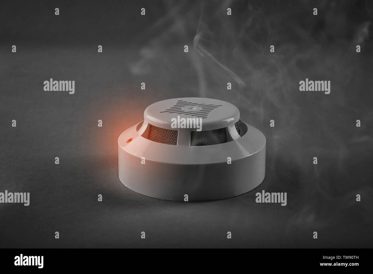 Smoke detector with warning light on grey background Stock Photo - Alamy