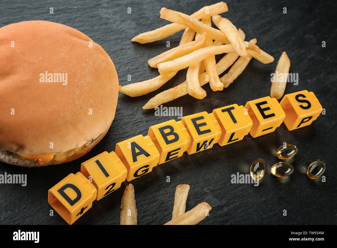French fries, burger and cubes with word "Diabetes" on dark background ...