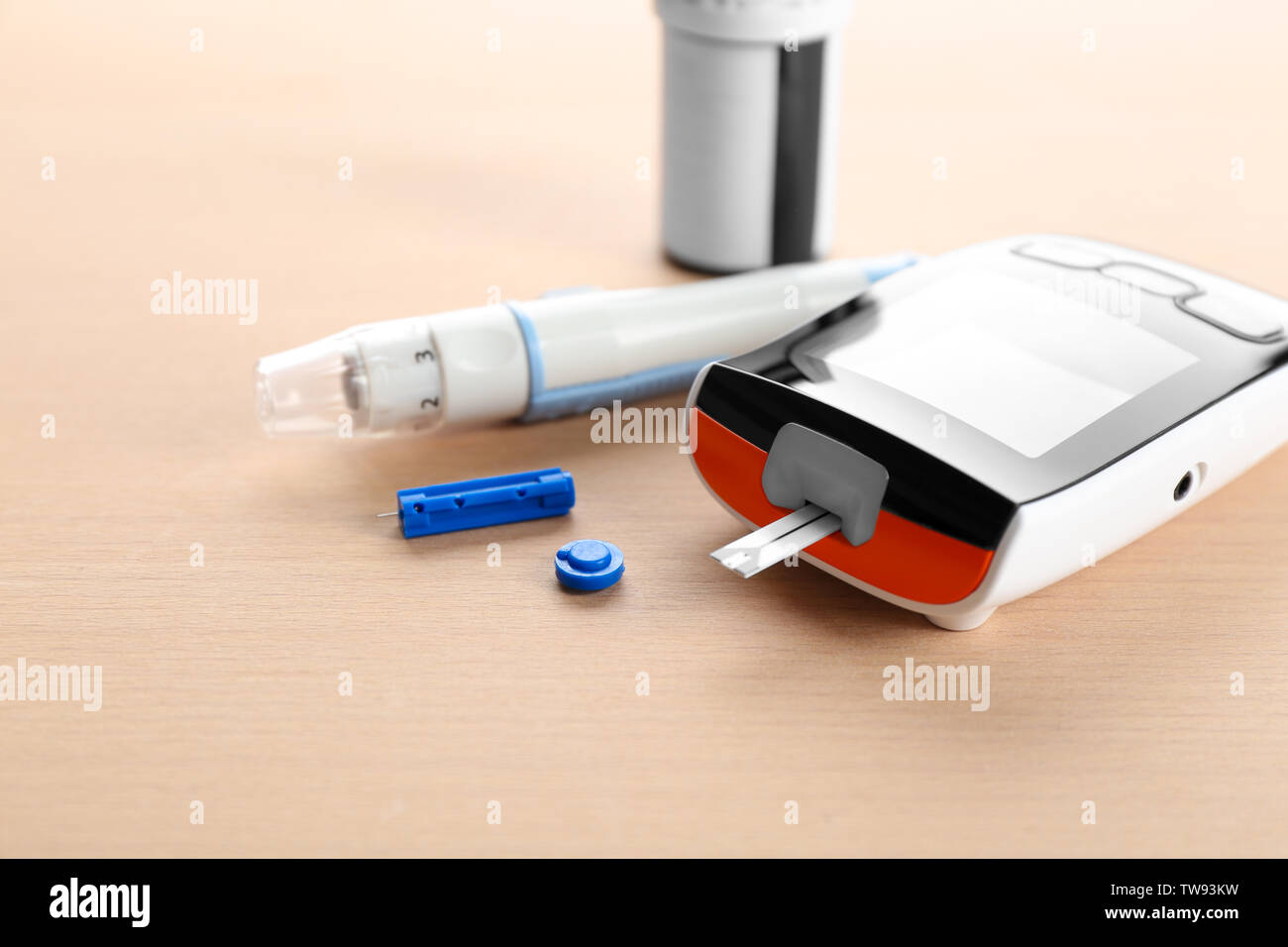 Digital glucometer and lancet pen on table. Diabetes management Stock ...